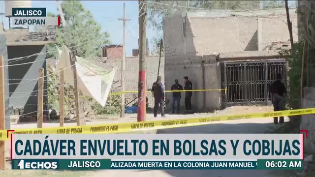 Cuerpo sin vida de una persona envuelta en bolsas y cobijas